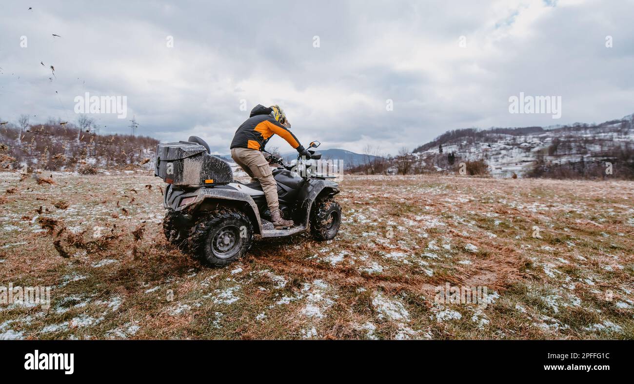 A man drives an ATV in the mud. Drift driving an ATV quad in mud and ...