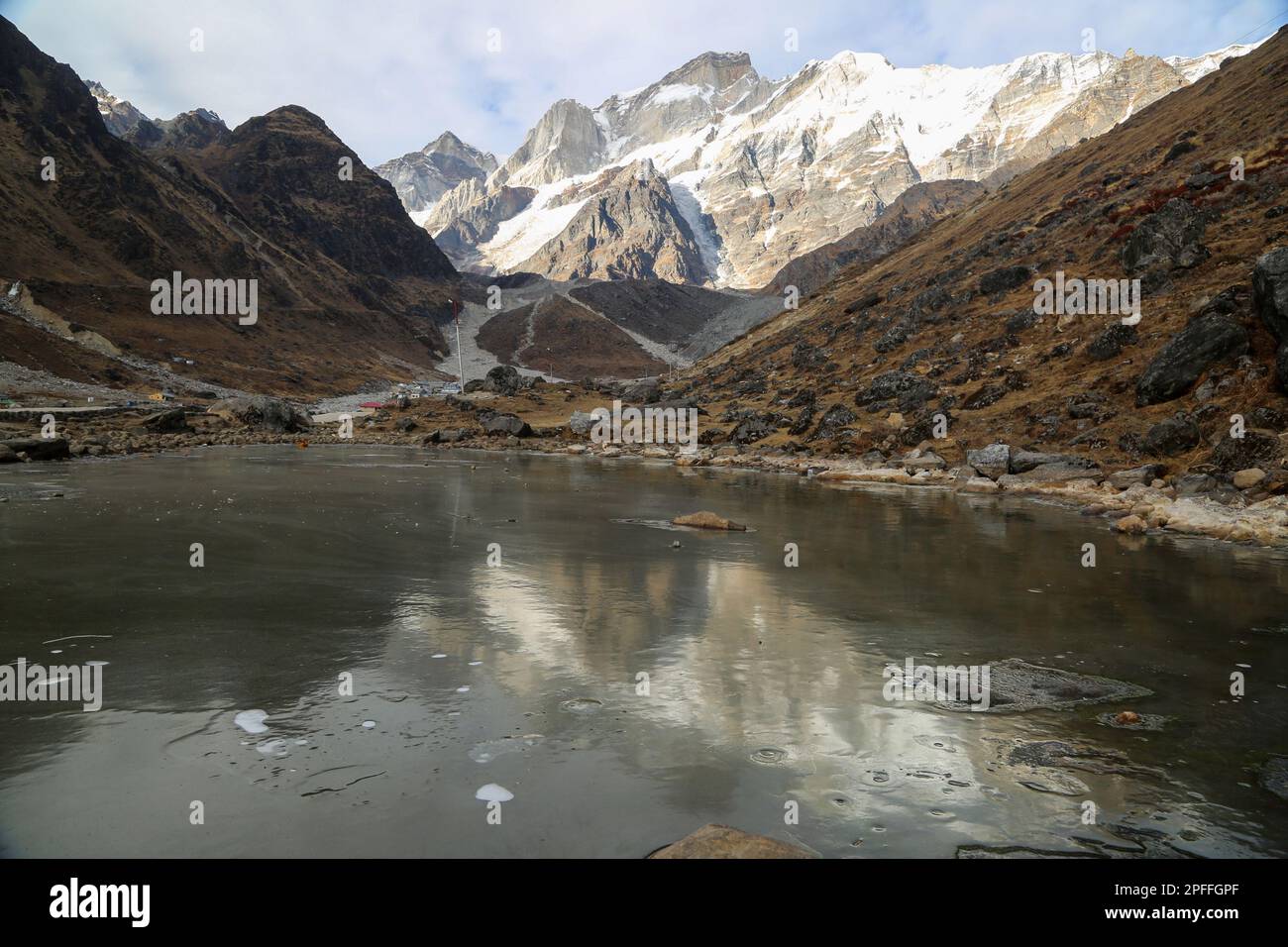 Snow covered peak and a lake in high altitude of Himalaya. Dotted with ...