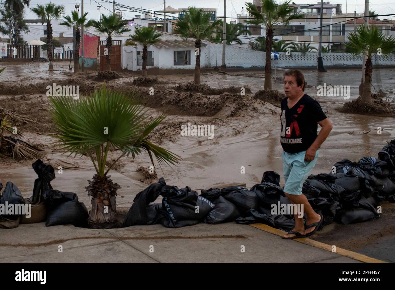 Lima, Peru. 14th Mar, 2023. A man walks along a flood-affected area in ...