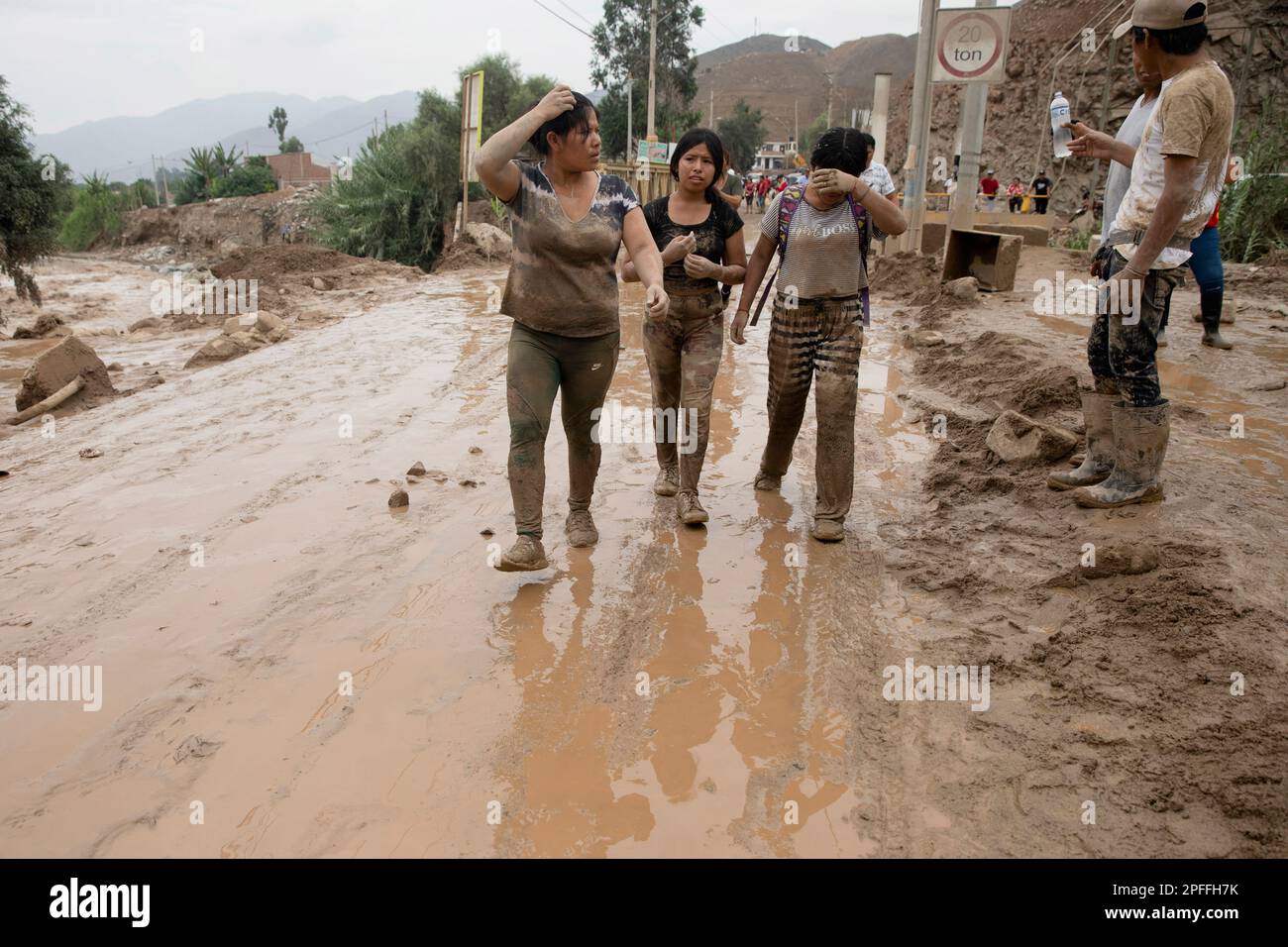 Lima, Peru. 15th Mar, 2023. People walk on a flood-affected street in ...
