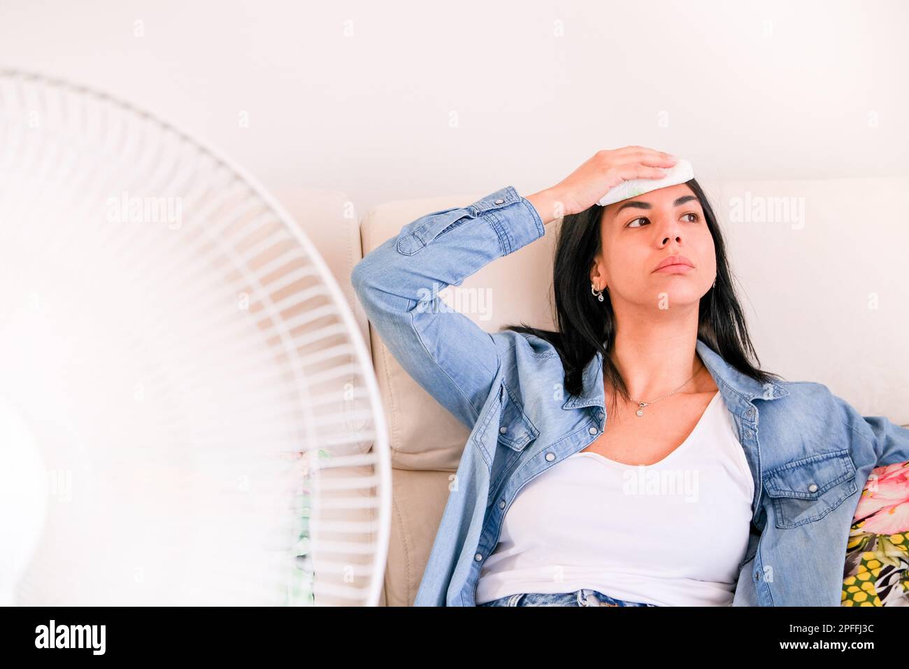 Woman suffering summer heat trying to stay cool and comfortable during ...