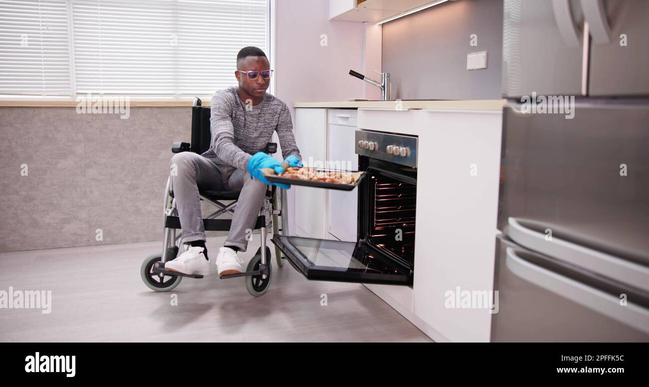Disabled Man Using Microwave Oven For Baking In Kitchen Stock Photo - Alamy