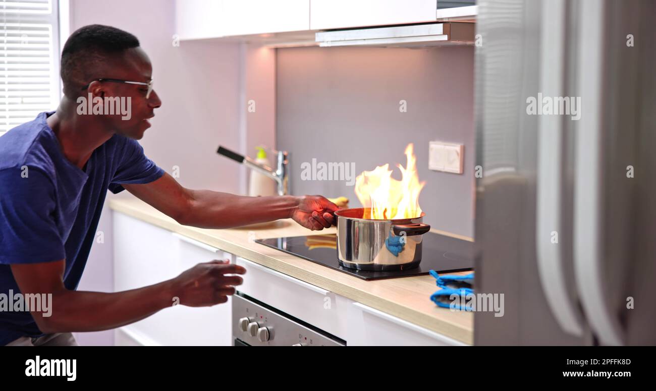 Kitchen Cooking Mistake And Fire Disaster. Man Shocked Stock Photo - Alamy