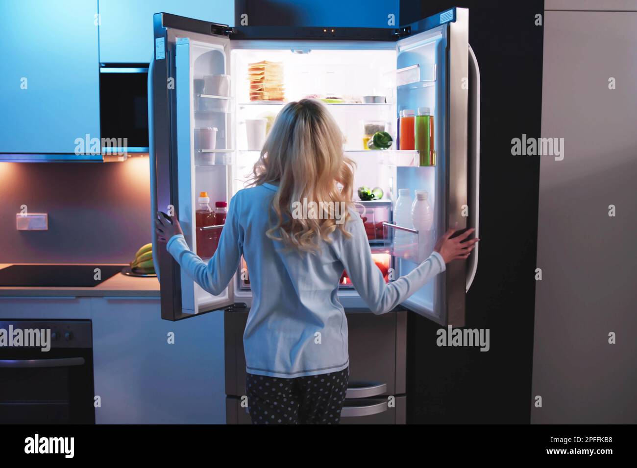 Hungry Woman At Night With Open Fridge Stock Photo - Alamy