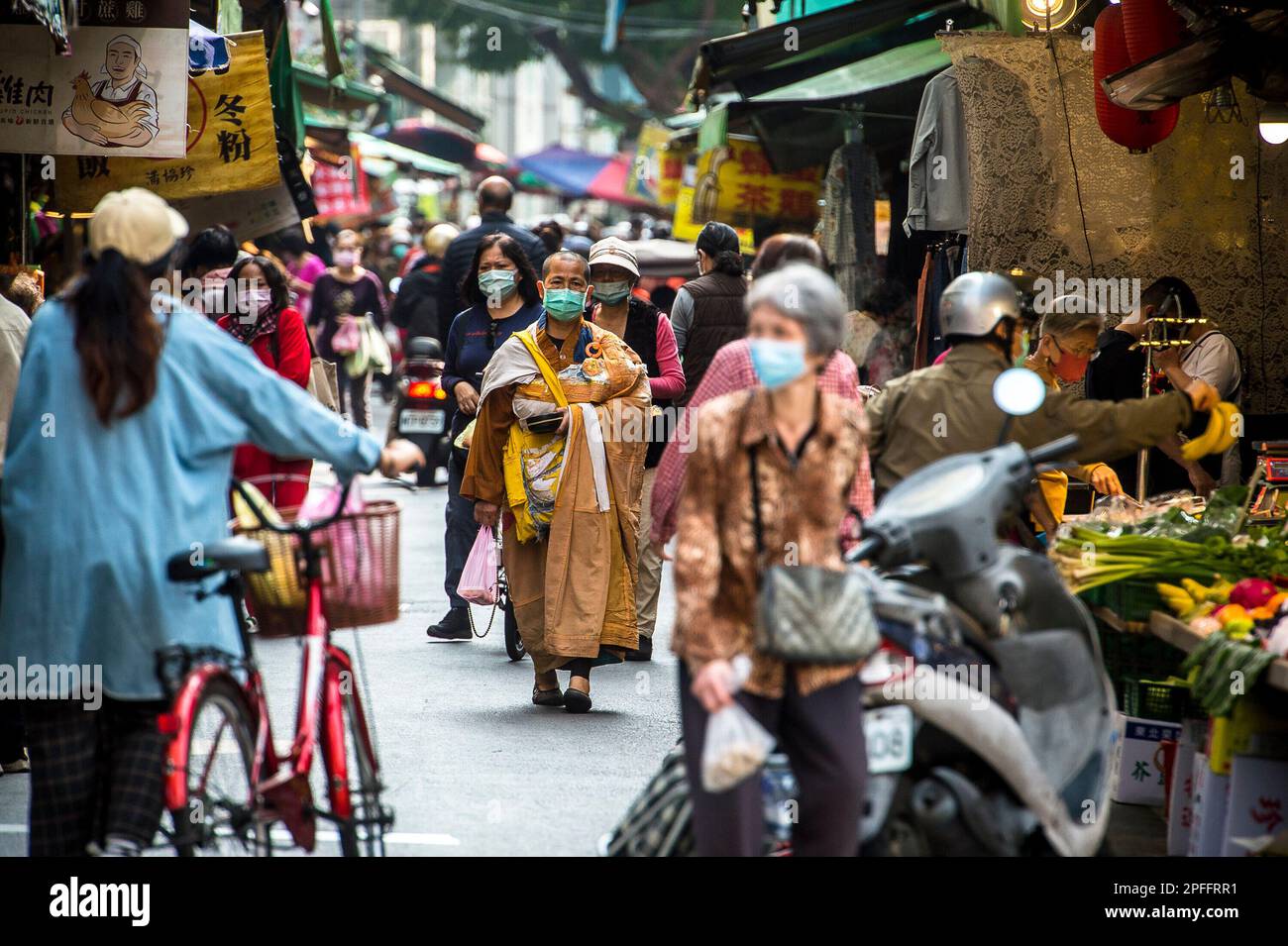 Taipei. 17th Mar, 2023. Buddhist monk stroll through morning bazaar in ...