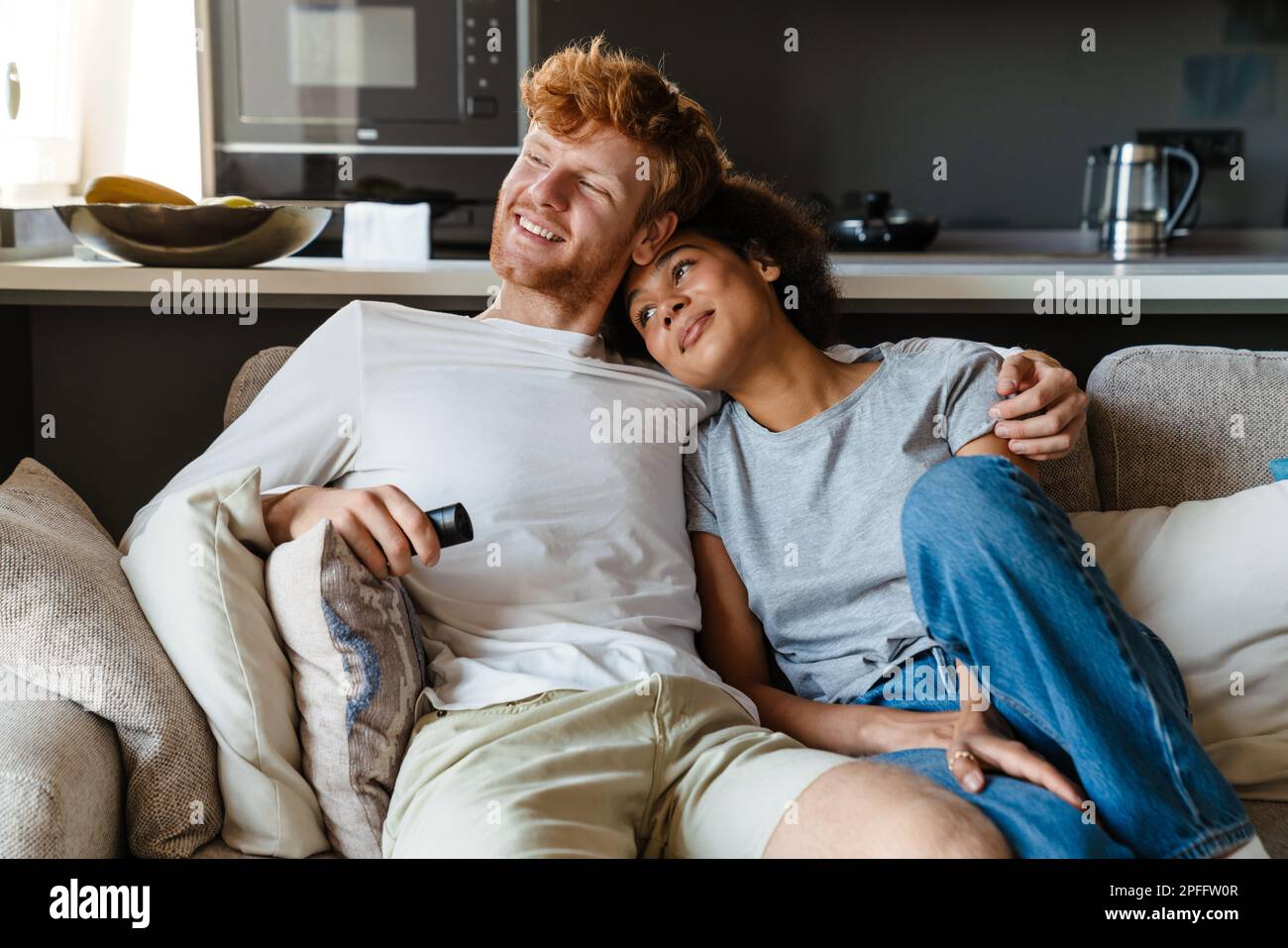 Young Beautiful Happy Interracial Couple Hugging And Looking Aside