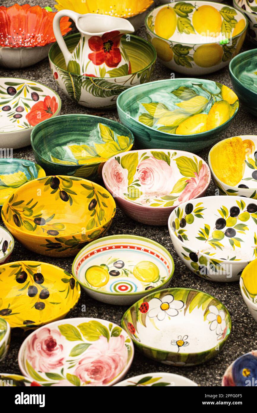 A colorful arrangement of ceramic bowls is displayed, each decorated ...