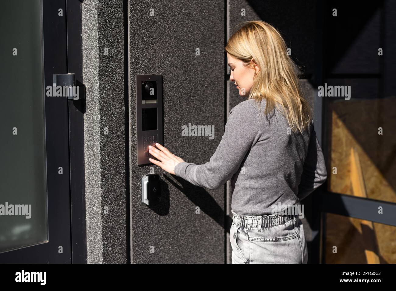 woman using intercom at building entrance Stock Photo - Alamy