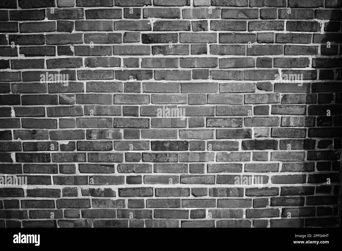 Typical common brick wall with lots of bricks and layers in a black and ...