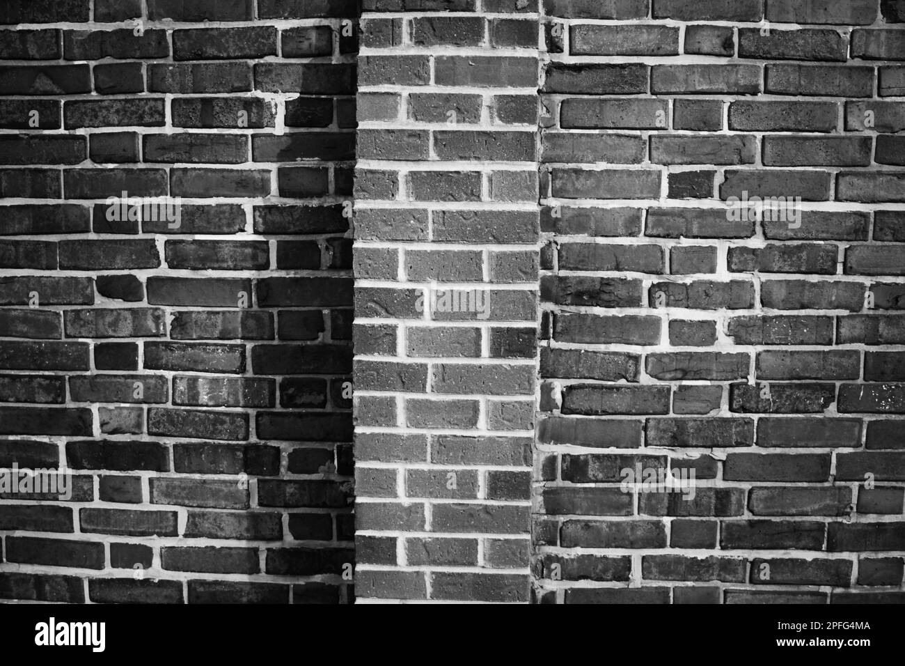 Typical common brick wall with lots of bricks and layers in a black and ...