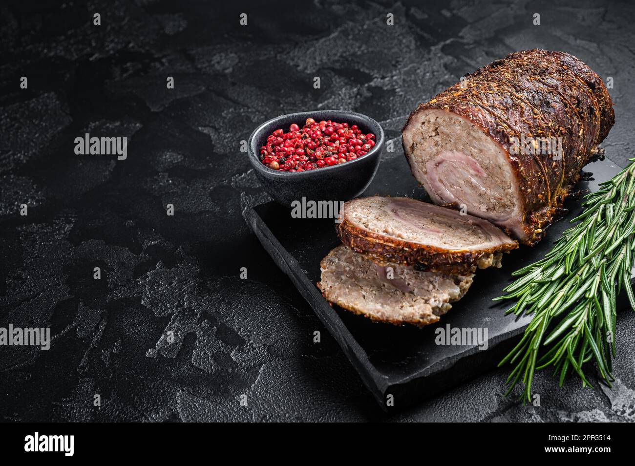 Baked pork roulade Porchetta, rolled pork meat on a marble board with ...