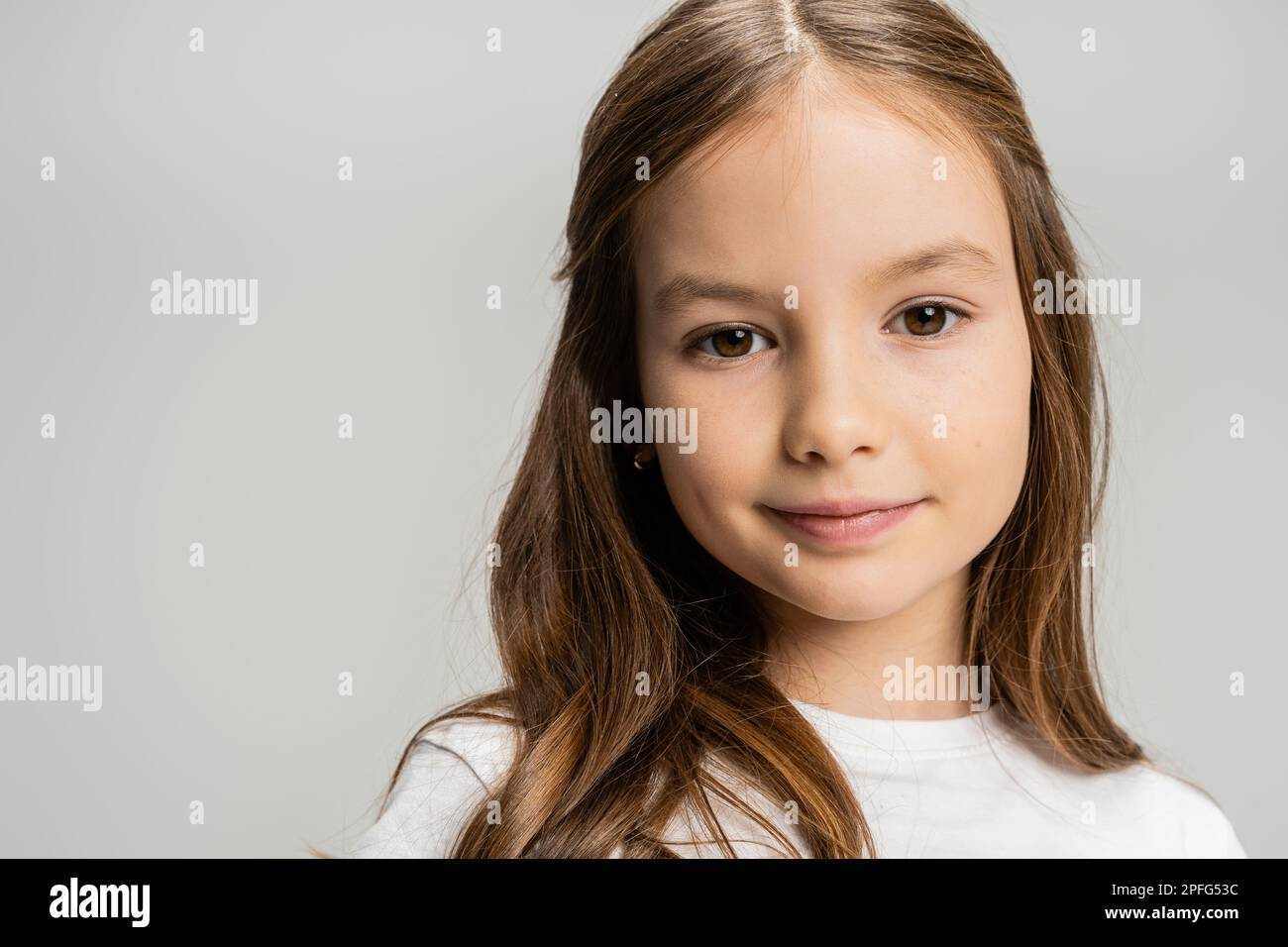 Portrait of preteen girl in white t-shirt looking at camera isolated on ...