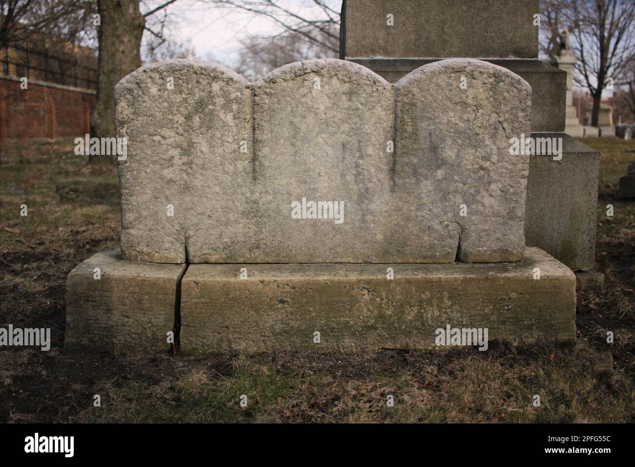 A vintage traditional medieval triple tombstone with a blank epitaph ...