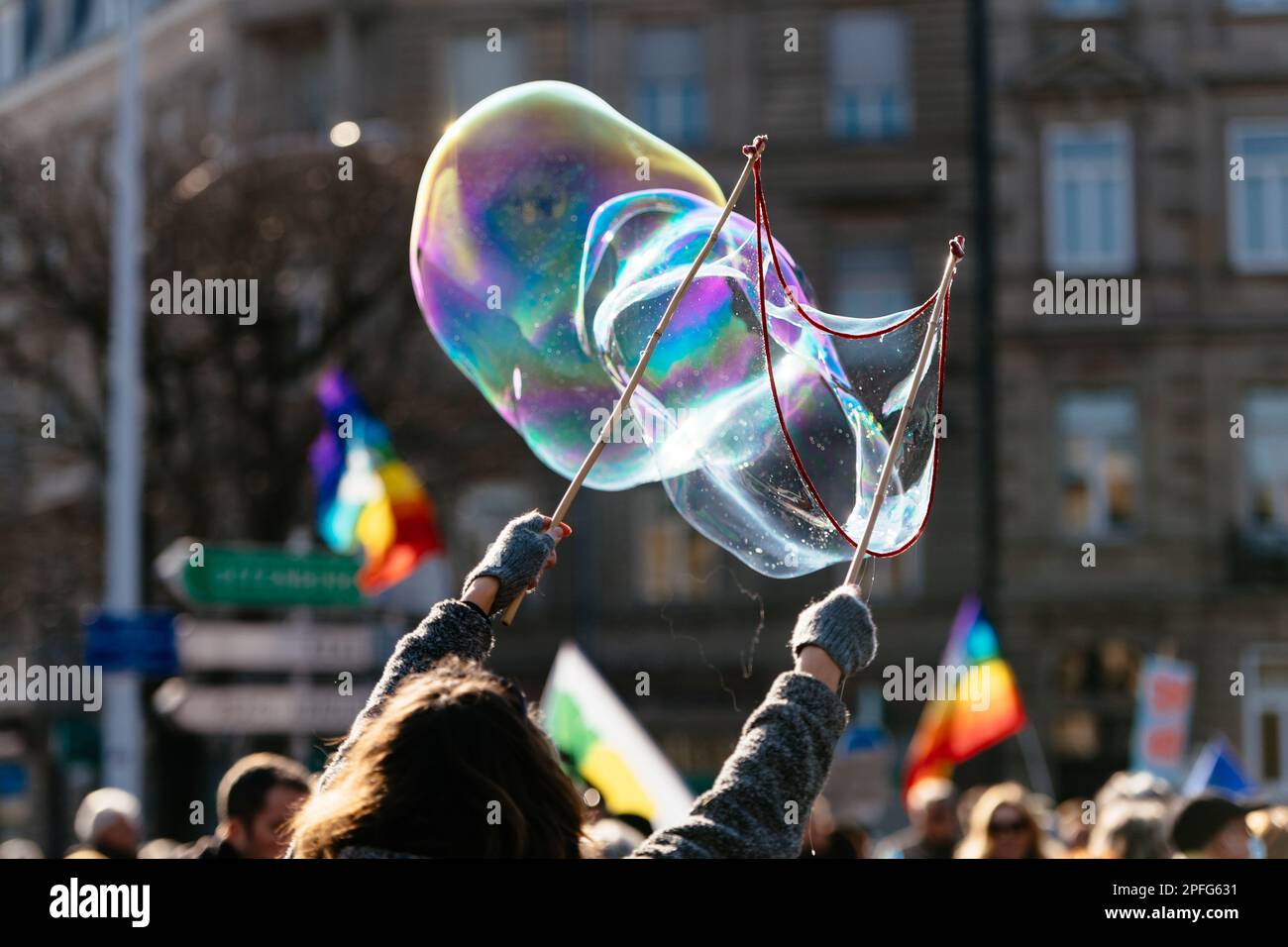At a vibrant festival, multi-colored bubbles fill the air as someone in ...