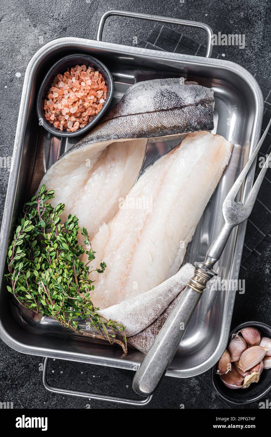 Raw haddock fish fillets, whitefish meat in kitchen tray with thyme ...