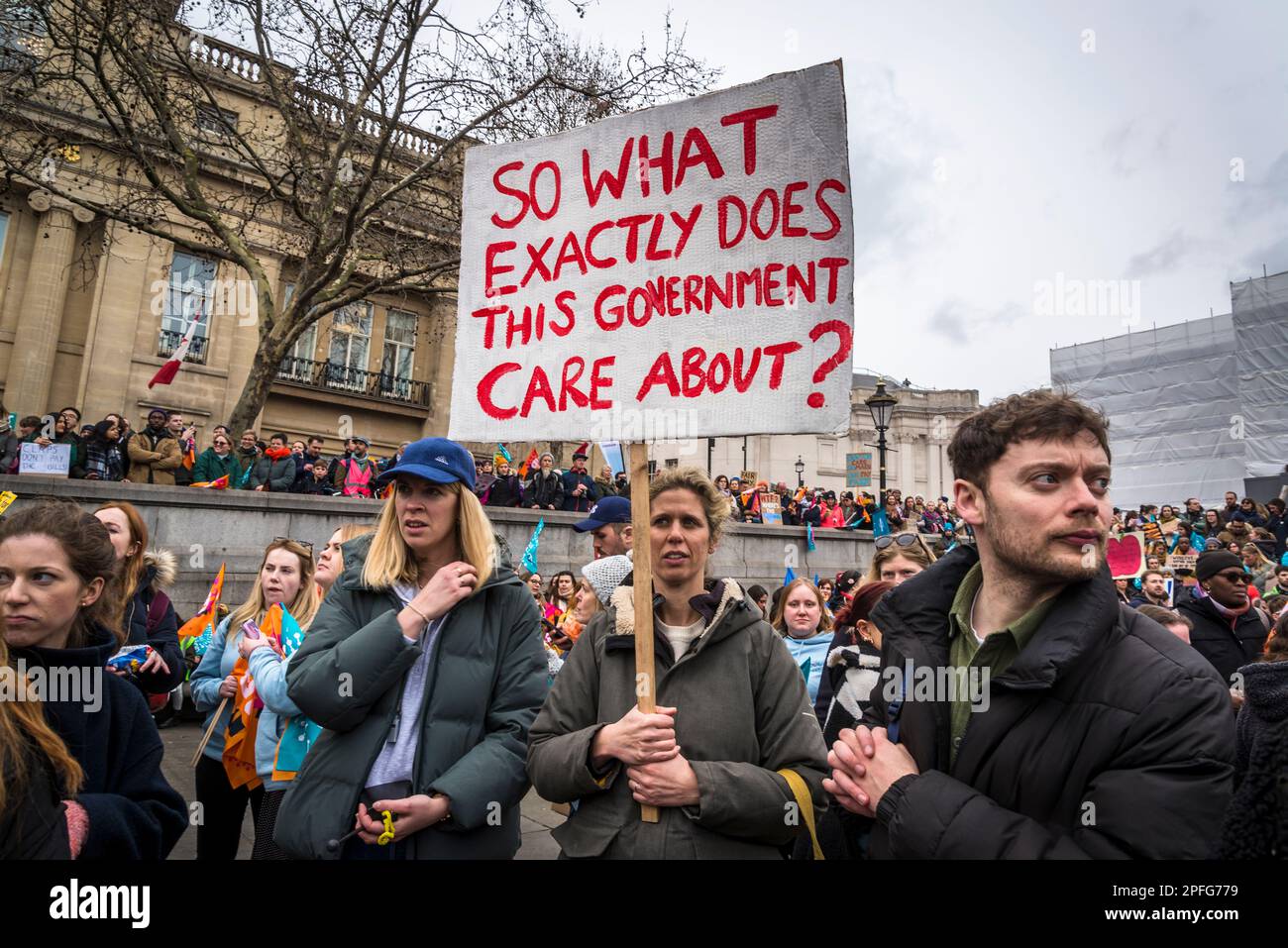 Woman carrying placard asking 'What Exactly does this Government care ...
