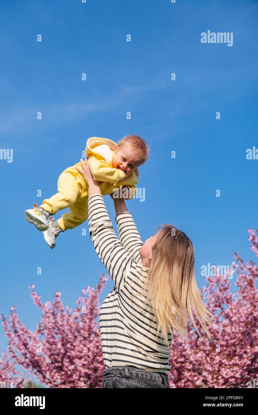 Adorable baby thrown up by cheerful mom Stock Photo - Alamy