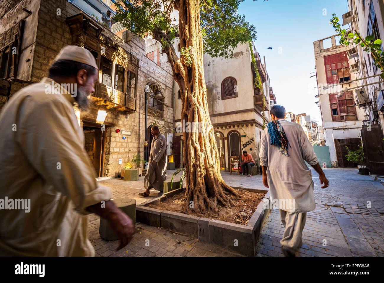 Scenic view of Arab men passing a tree in the courtyard of a ...