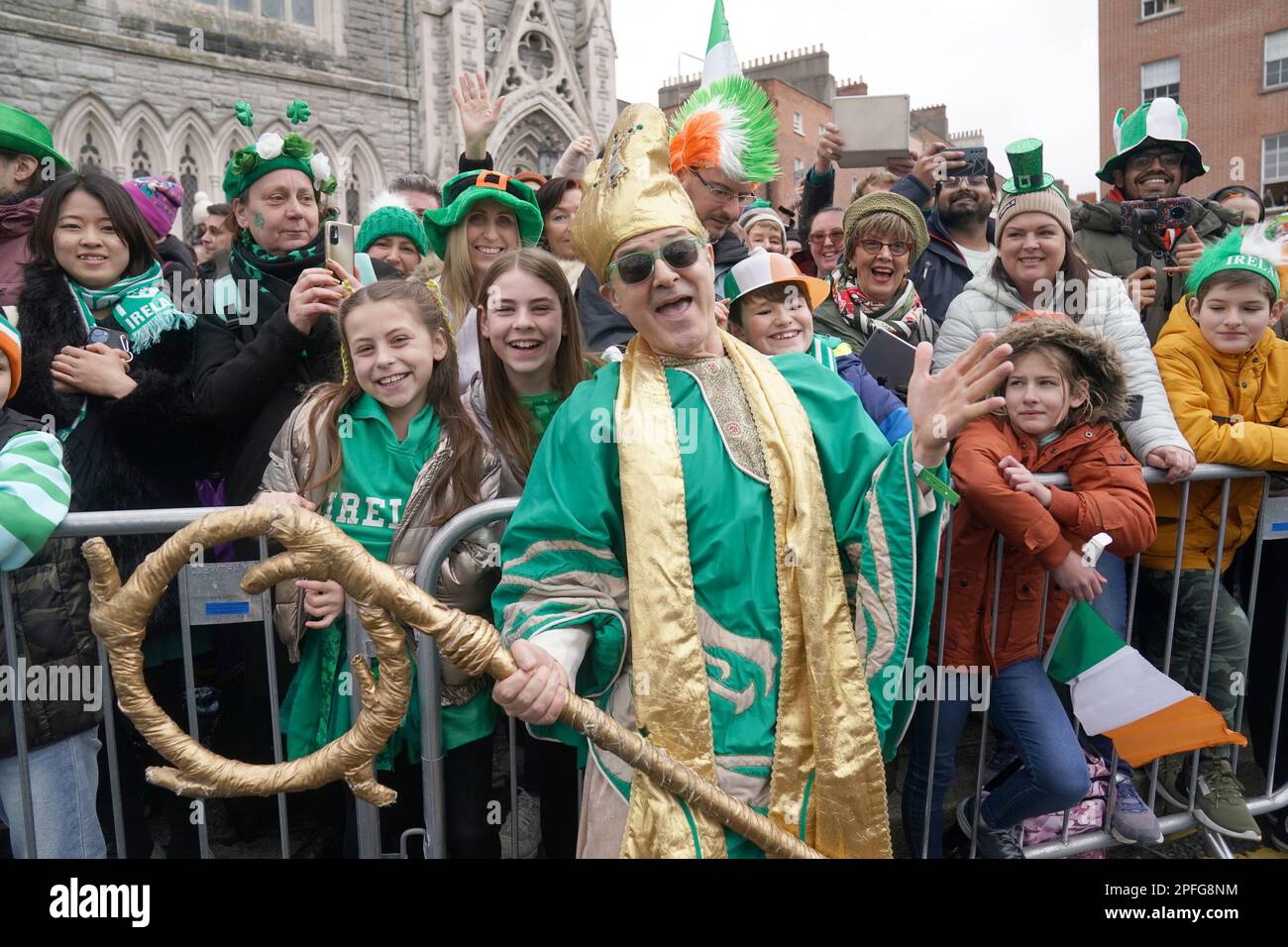 A performer poses with spectators during the St Patrick's Day Parade in ...
