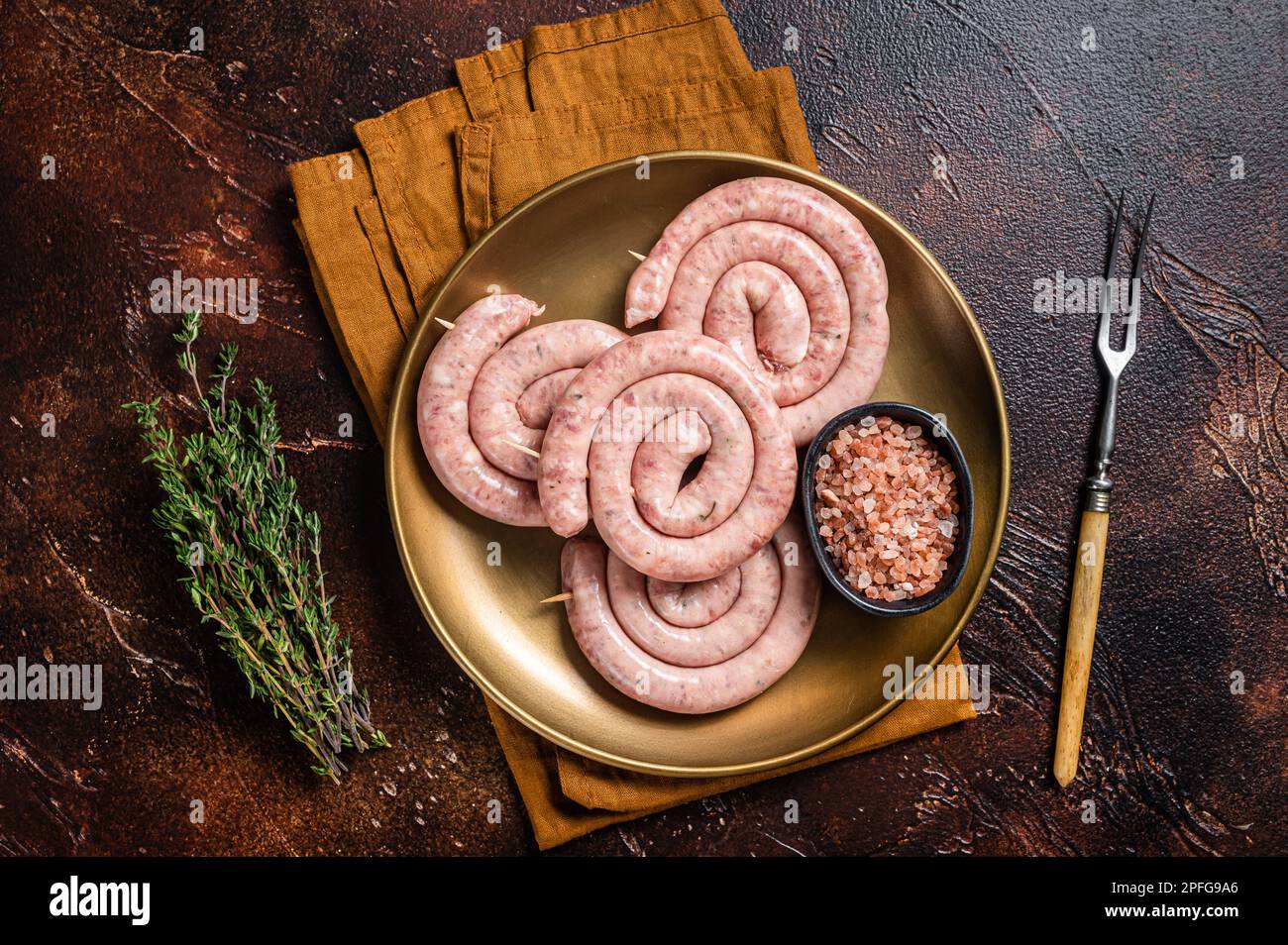 Raw spiral pork sausages, uncooked Wurst. Dark background. Top view ...