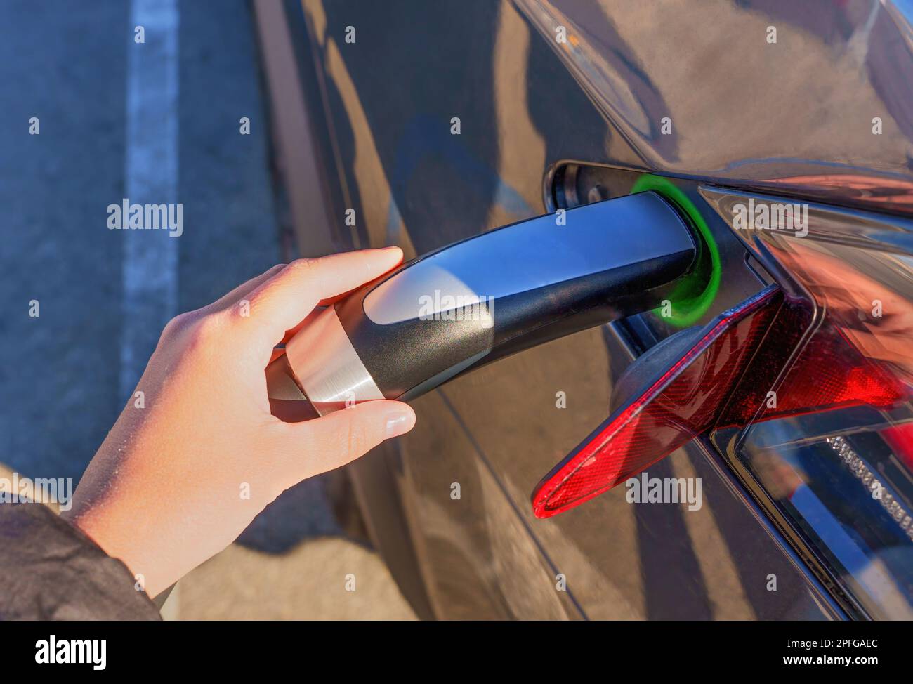 Hand plugging in the electric vehicle using the connector at the ...
