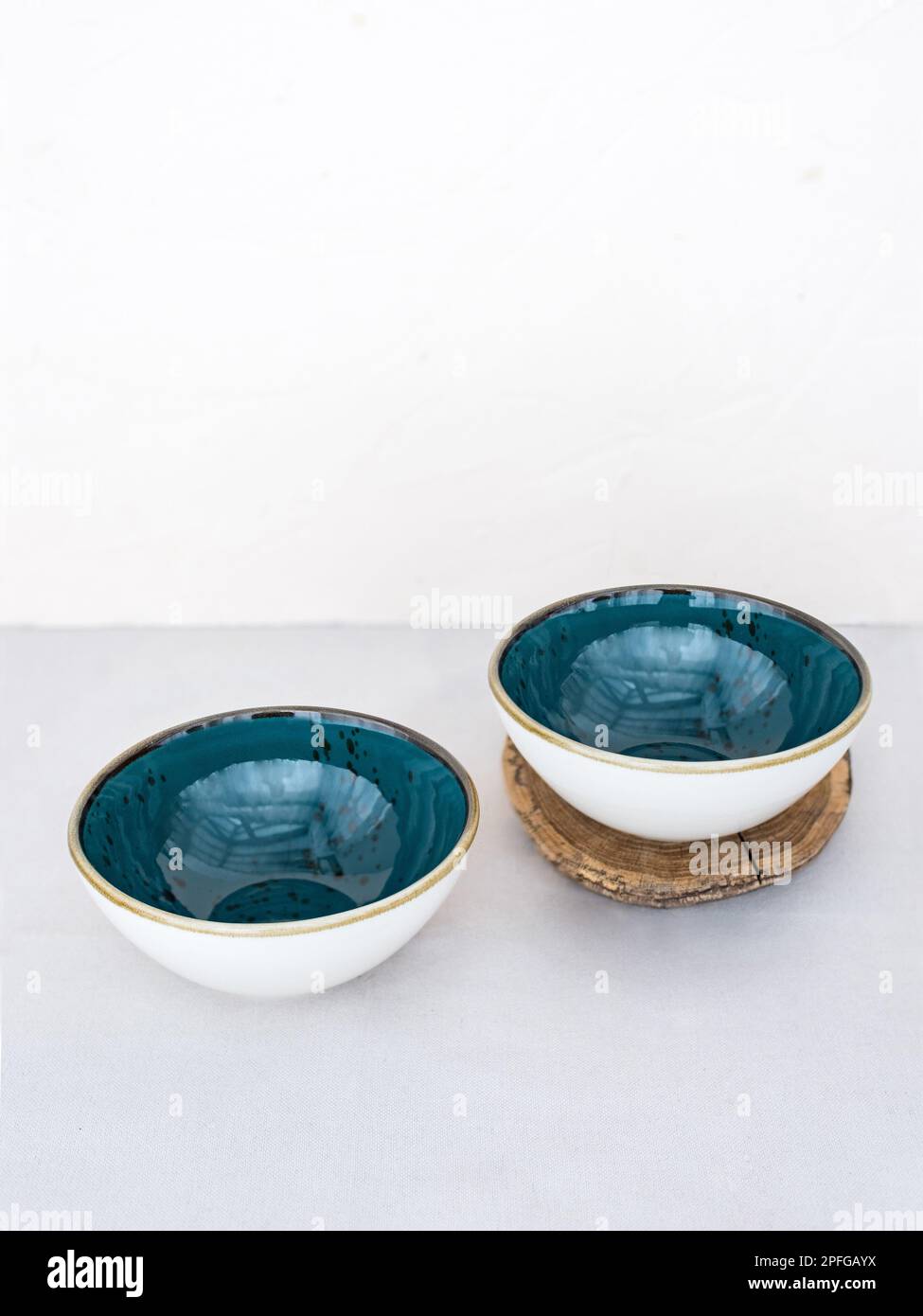 Two empty blue soup bowlson table on white background for your copy ...