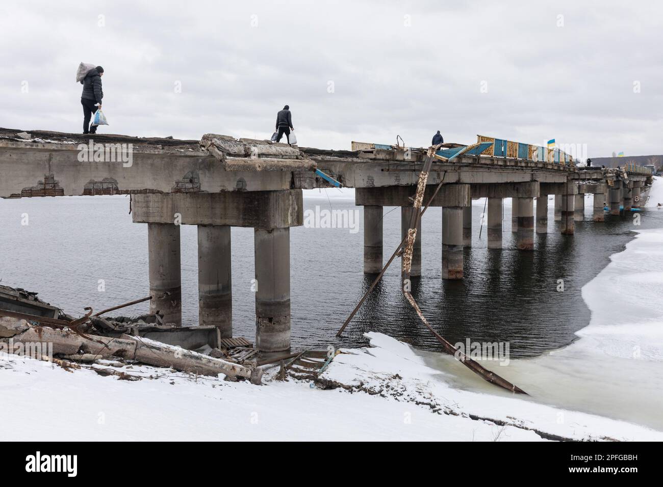 Locals are seen at a pedestrian crossing over the destroyed bridge over ...