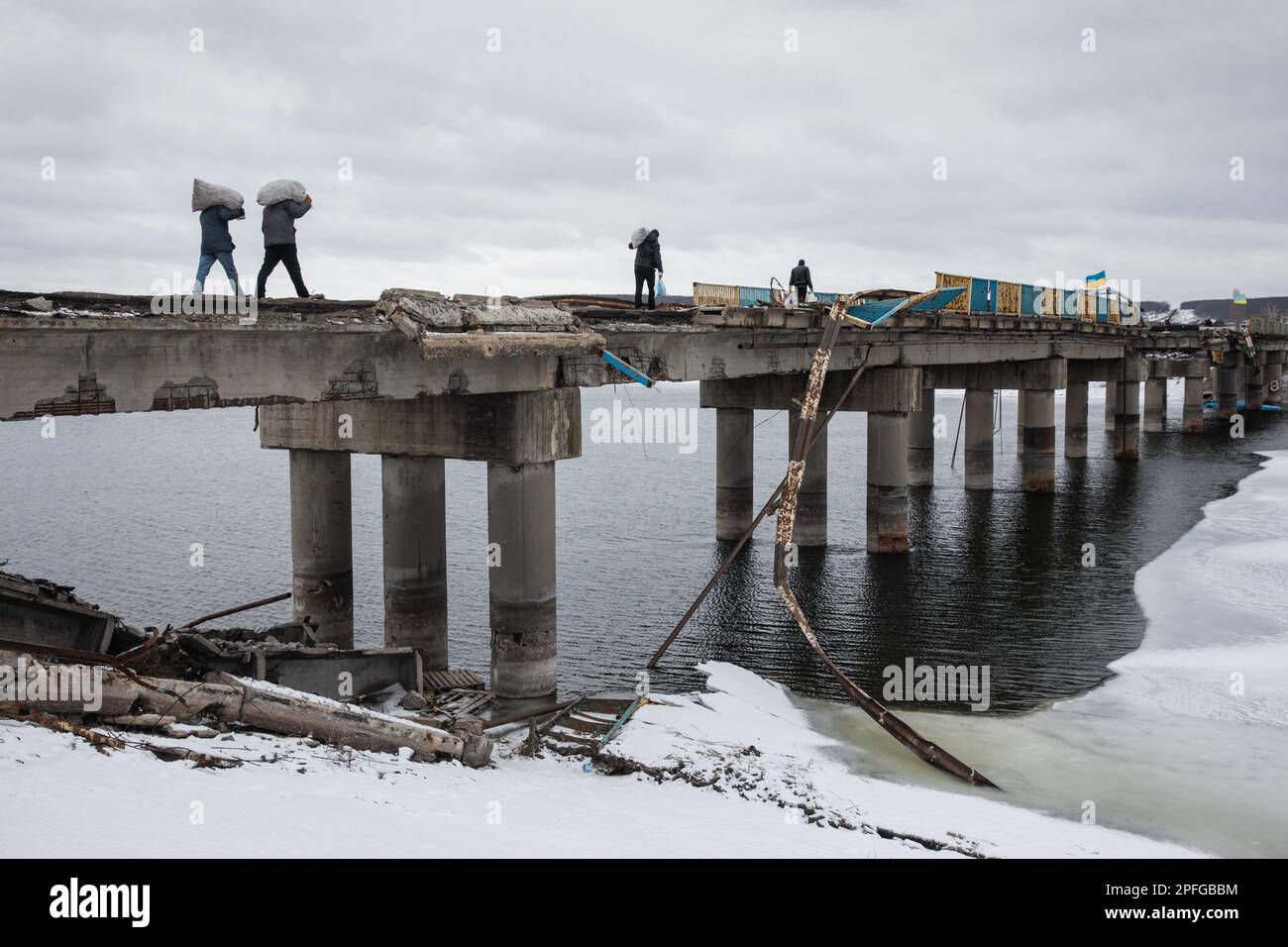 Locals are seen at a pedestrian crossing over the destroyed bridge over ...