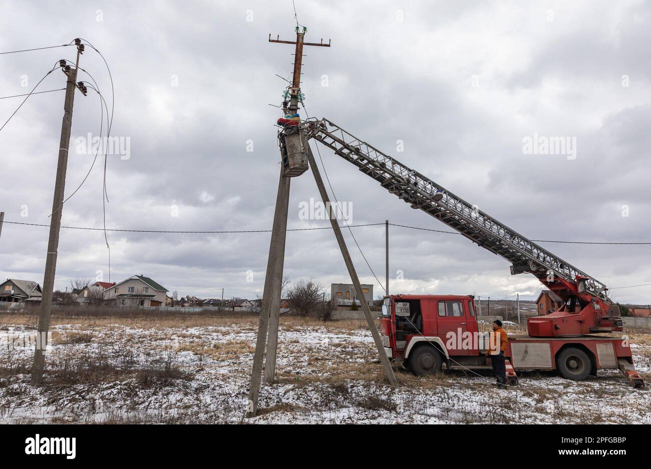 A team of electricians is seen working to restore a power line in ...