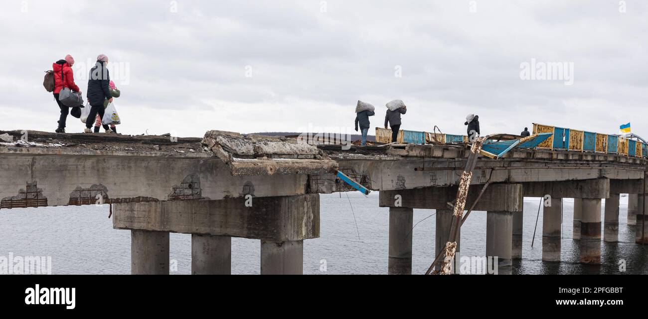 Locals are seen at a pedestrian crossing over the destroyed bridge over ...