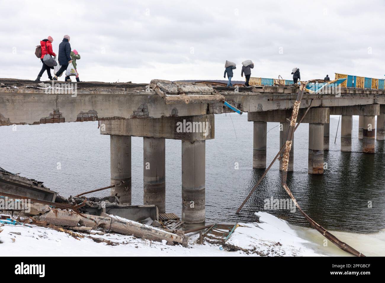Locals are seen at a pedestrian crossing over the destroyed bridge over ...