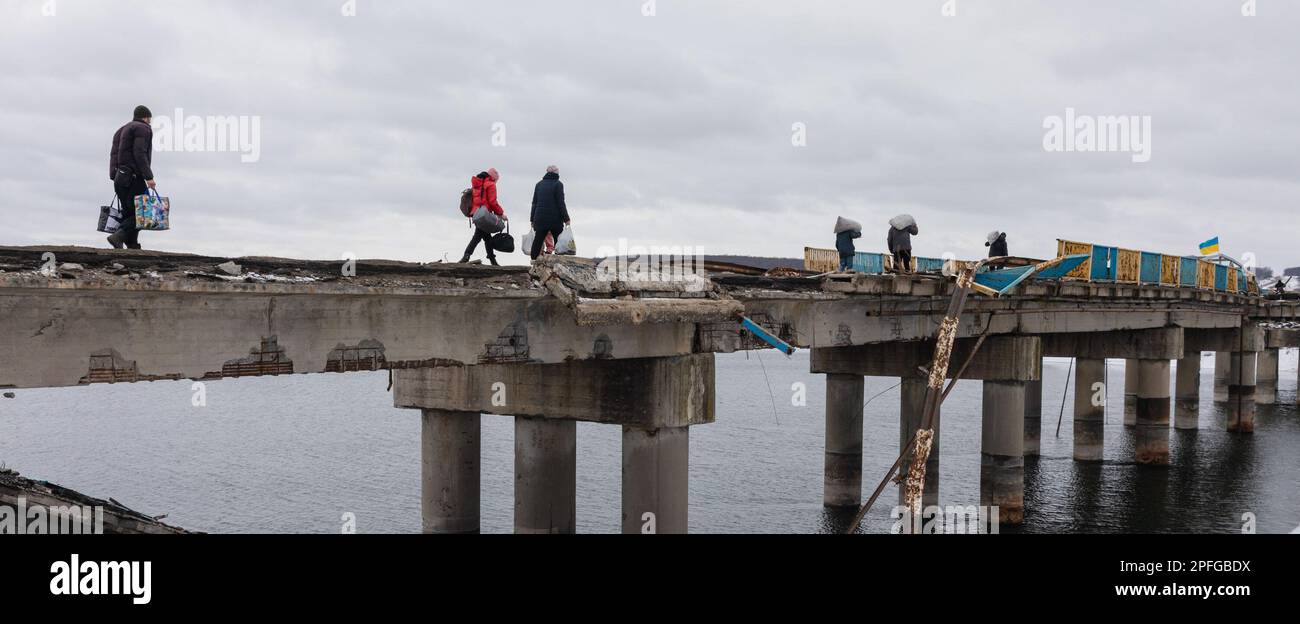 Locals are seen at a pedestrian crossing over the destroyed bridge over ...