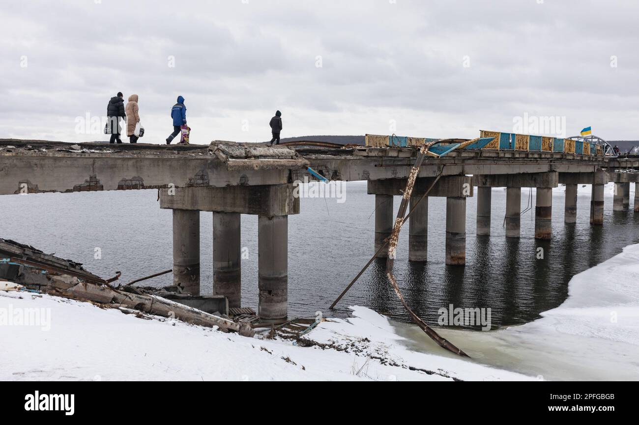 Locals are seen at a pedestrian crossing over the destroyed bridge over ...