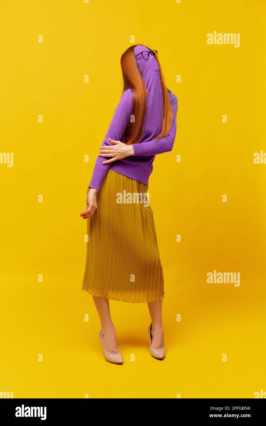 Faceless portrait of slim woman with long straight red hair wearing ...