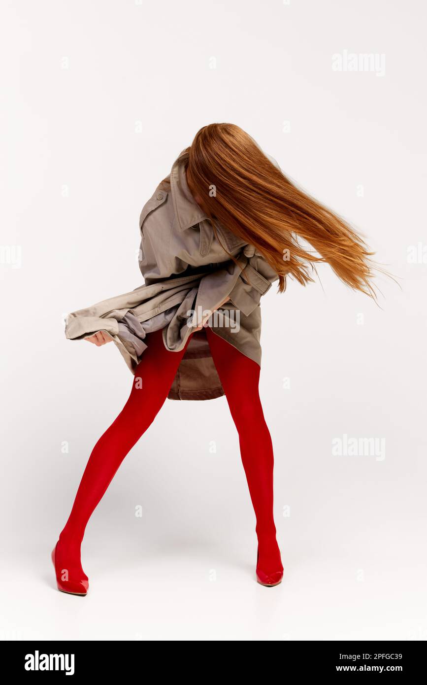 Impersonal human emotions. Stylish girl in grey coat and bright red ...