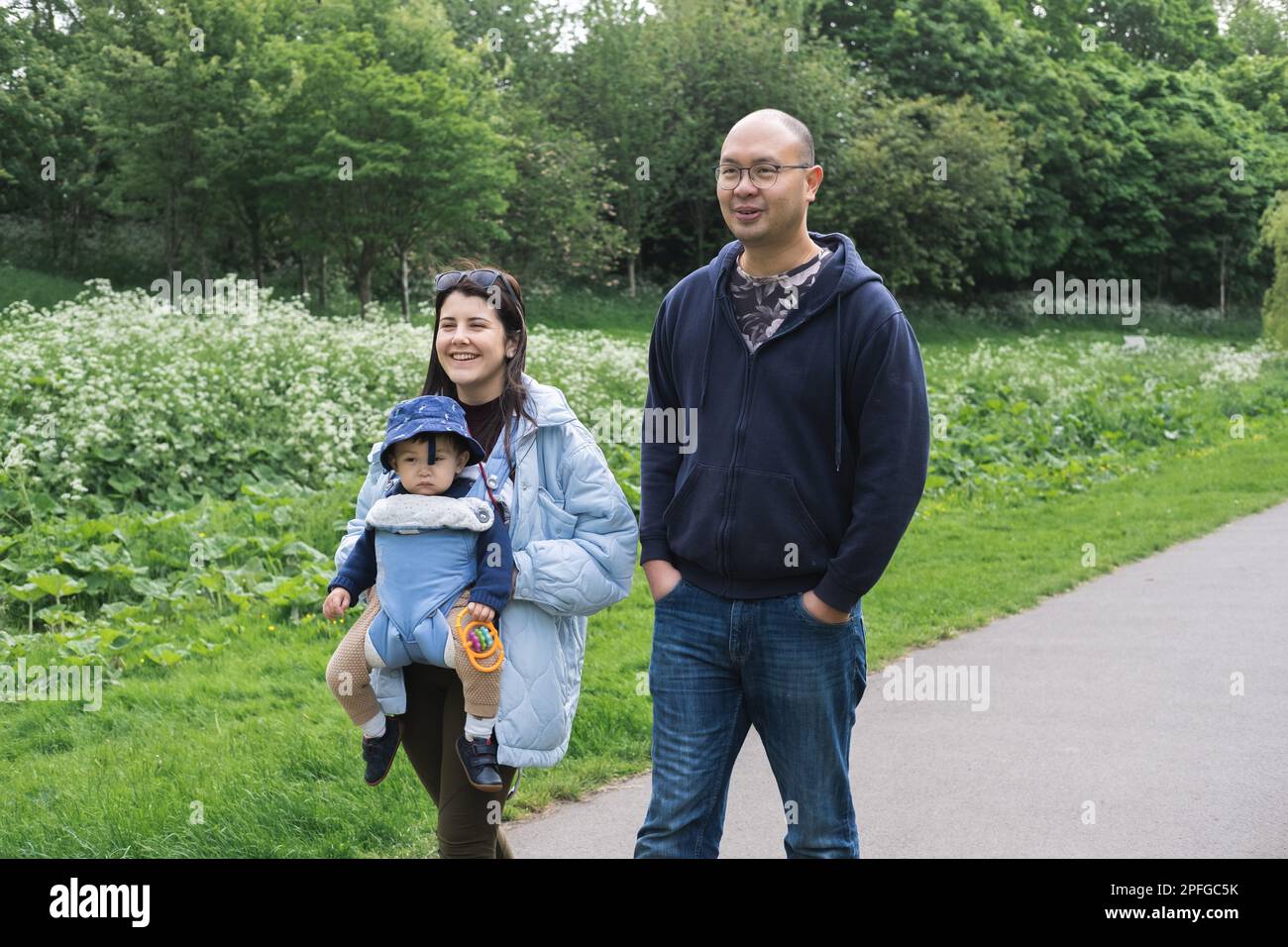 A multicultural family walking on a footpath in Figgate Park in ...