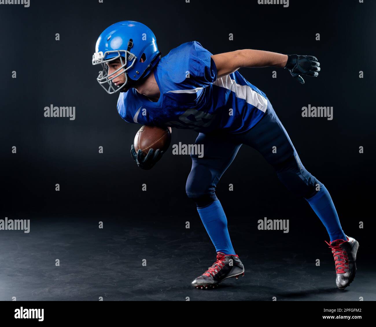 Full length portrait of a man in a blue american football uniform ...