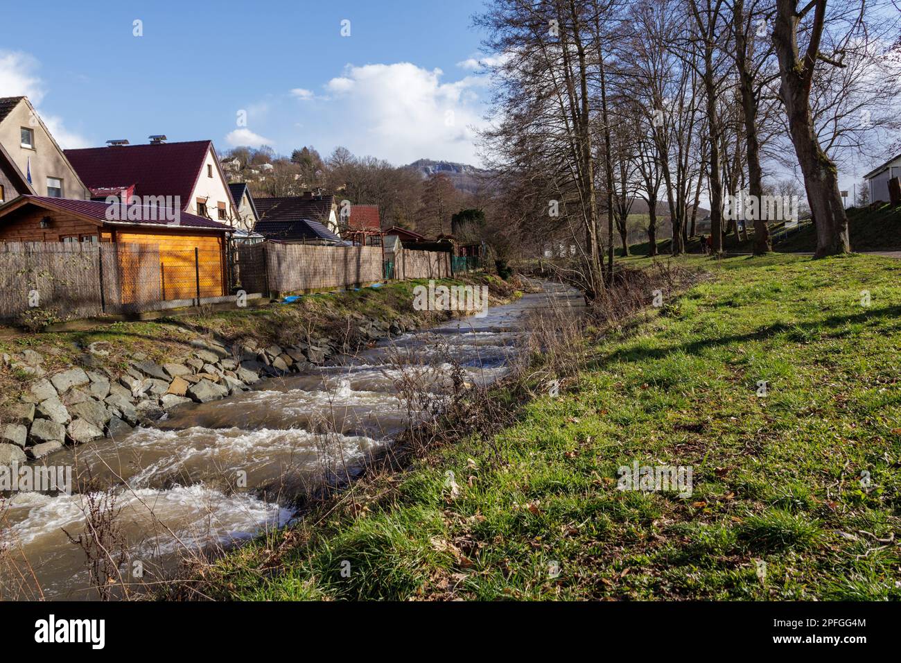The little river Oechse flows past gardens, trees and meadows in the ...