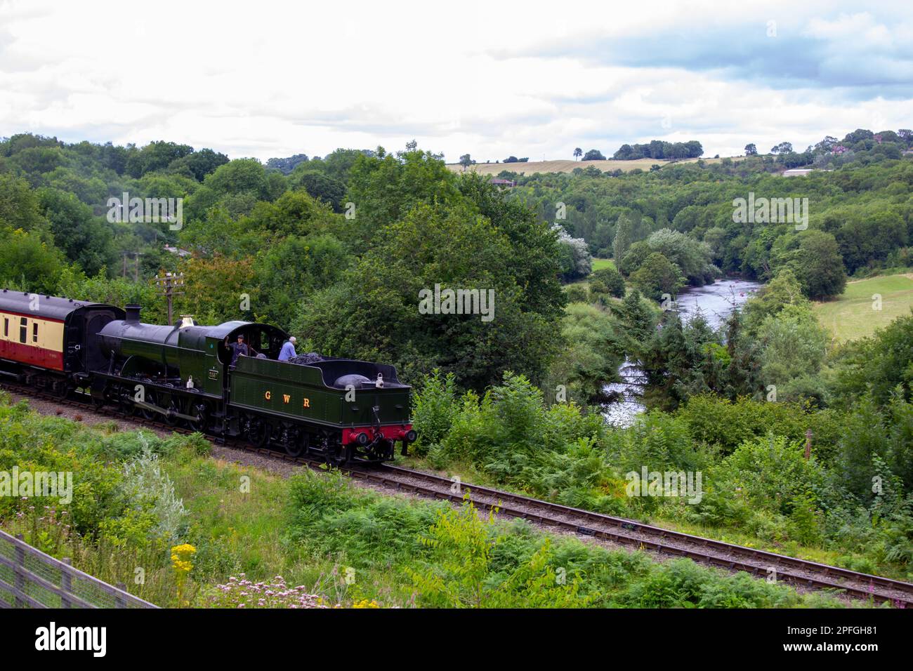 Steam train passing over a river Stock Photo - Alamy
