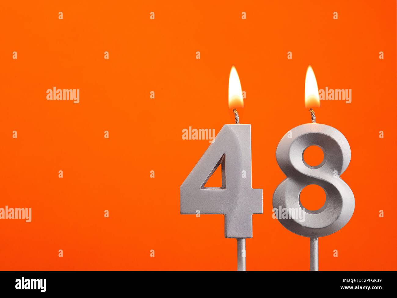 Candle number 48 - Birthday in orange background Stock Photo - Alamy