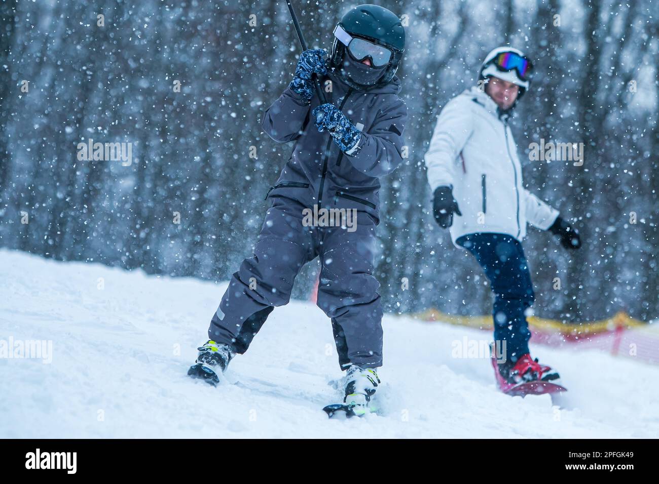 Family ski riding downhill with snow splash. Boy skiing in mountains ...