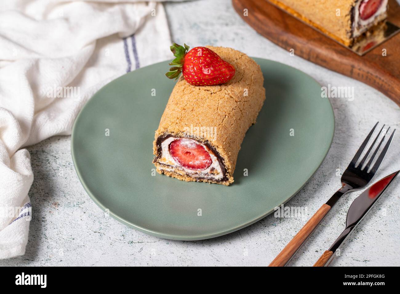 Rolled log cake. Strawberry and cream cake on a stone background ...