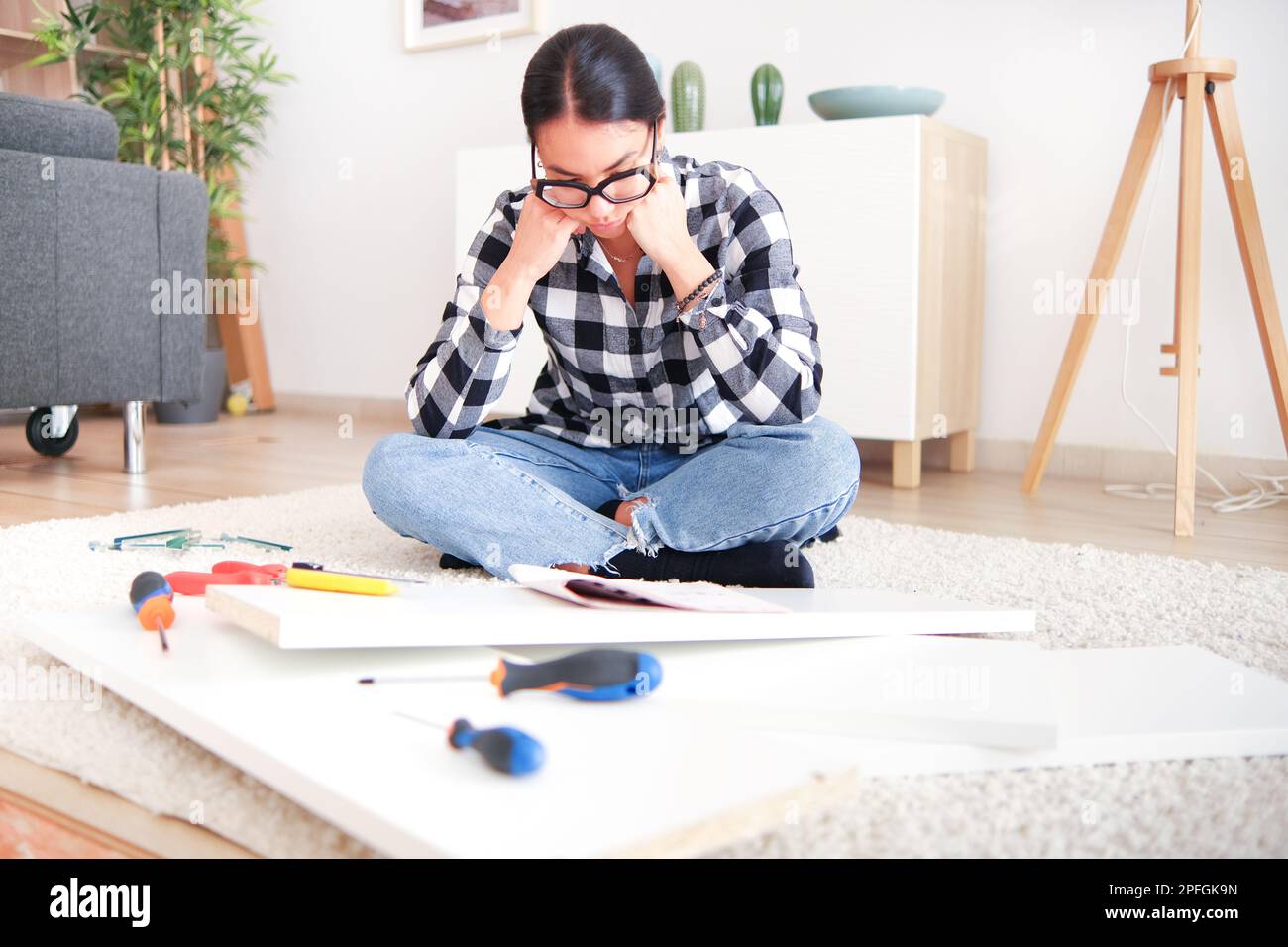 Woman experiencing frustration and stress while trying to assemble ...