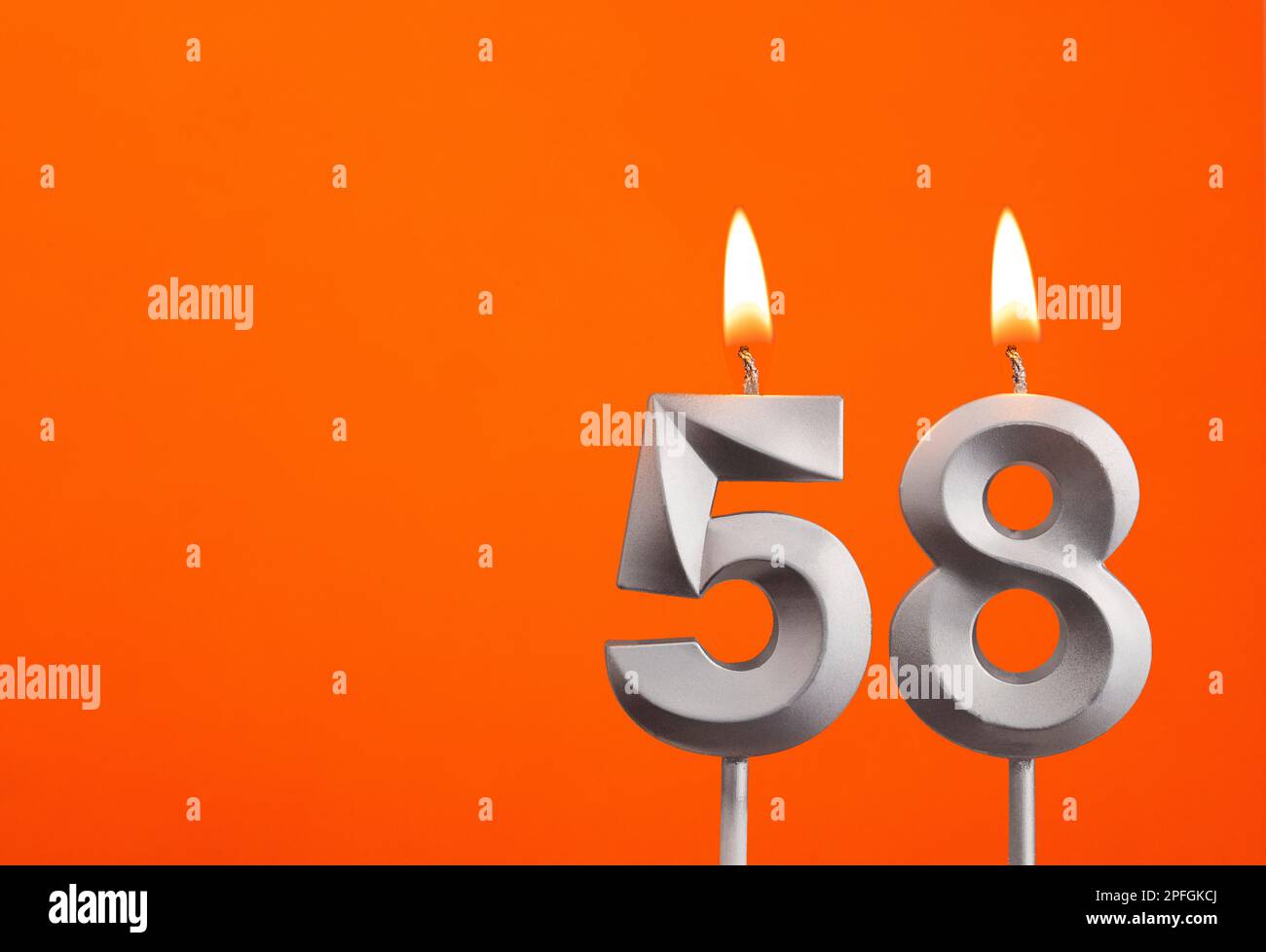 Candle number 58 - Birthday in orange background Stock Photo - Alamy
