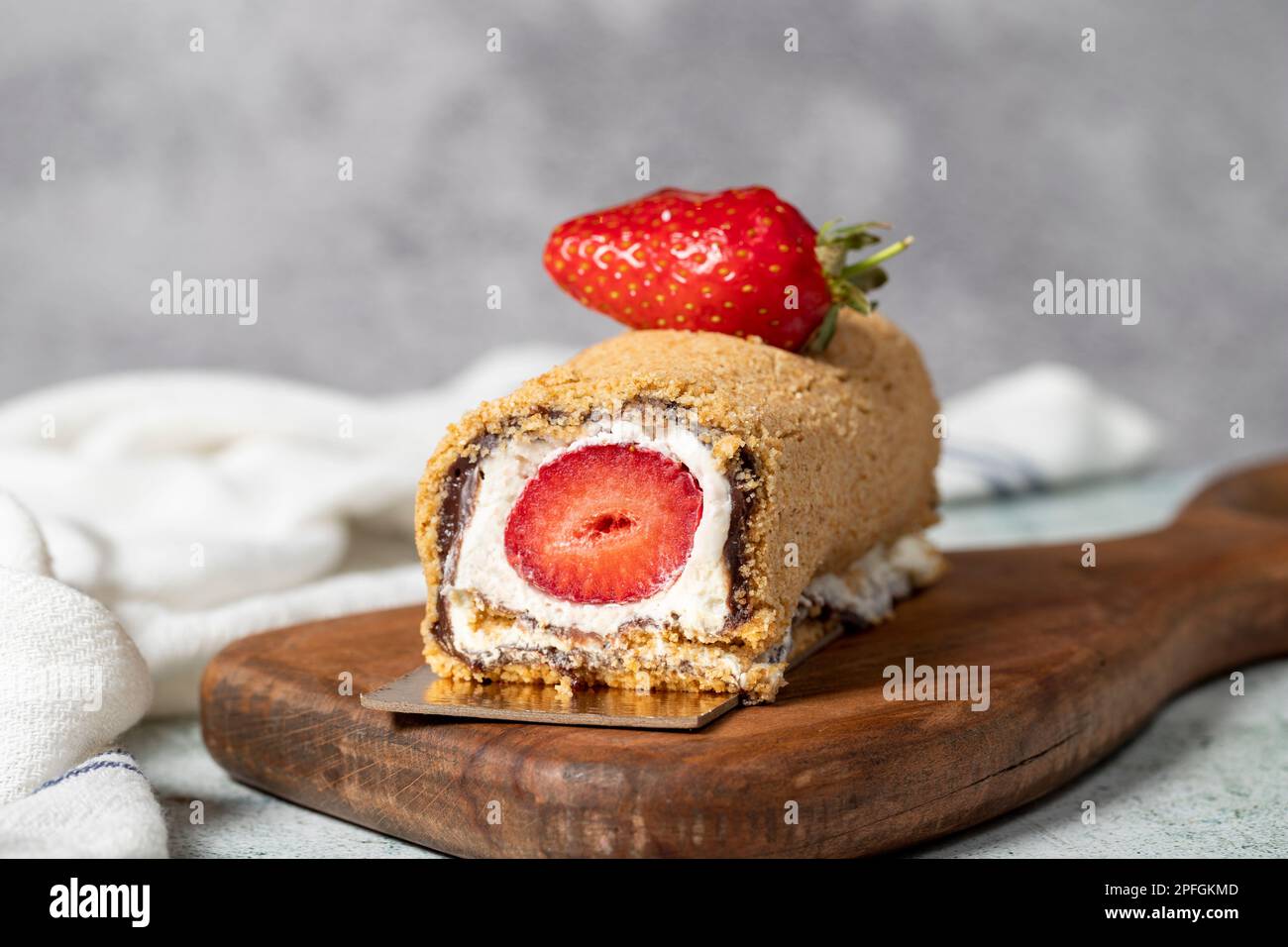 Rolled log cake. Strawberry and cream cake on a stone background ...
