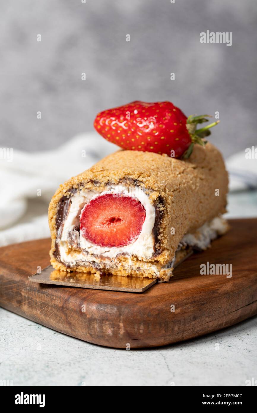 Rolled log cake. Strawberry and cream cake on a stone background ...