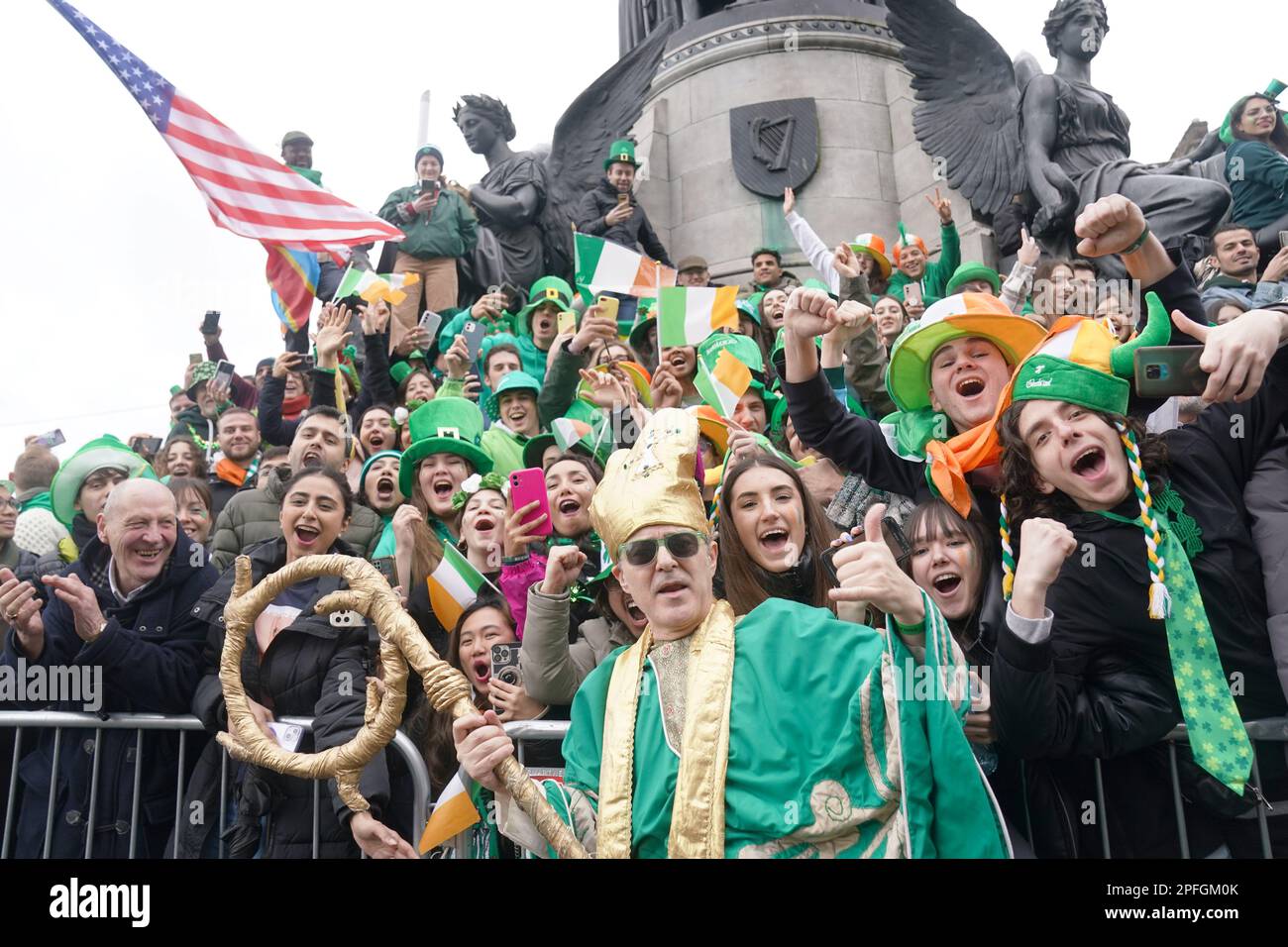 A performer poses with spectators at the St Patrick's Day Parade in ...