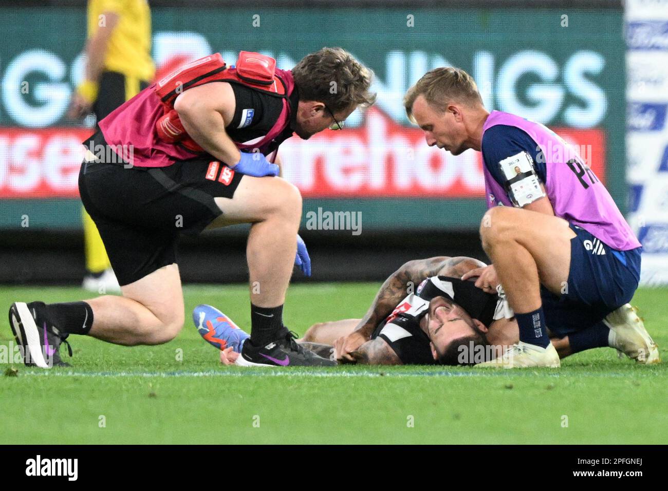 Jeremy Howe of Collingwood (centre) is seen with medical staff after ...