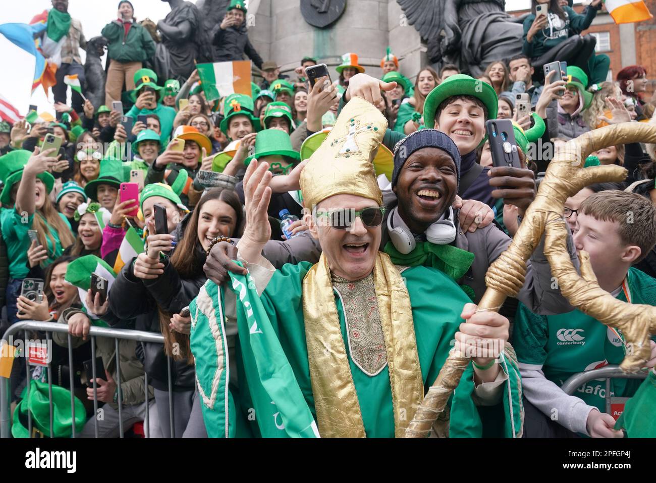 A performer poses with spectators at the St Patrick's Day Parade in ...