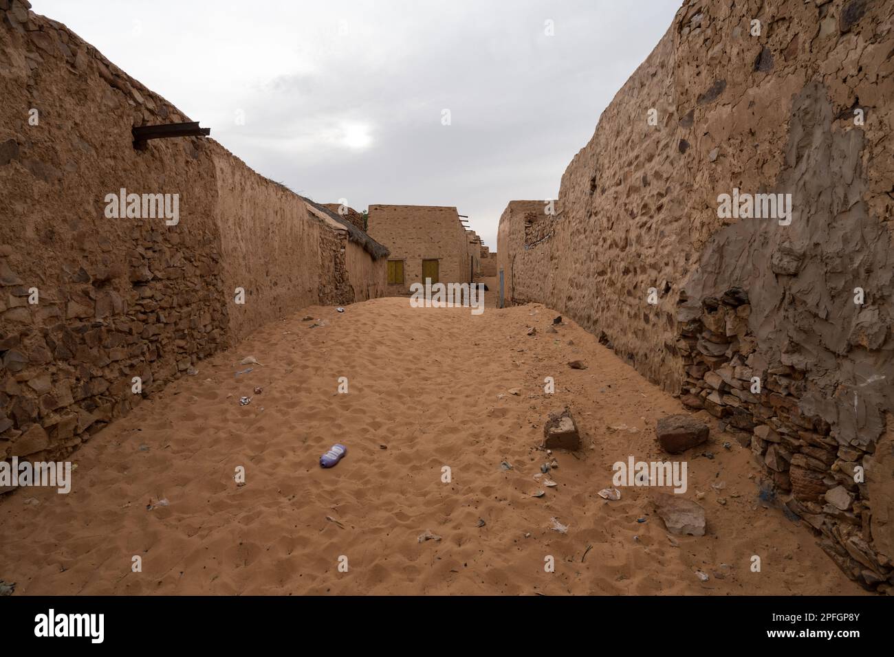 A narrow street in the ancient city of Chinguetti, Mauritania, lined ...